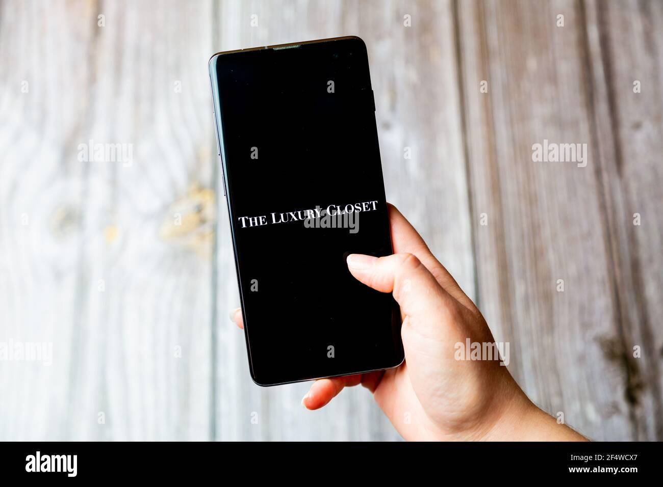 A mobile phone or cell phone being held in a hand with the Luxury ...