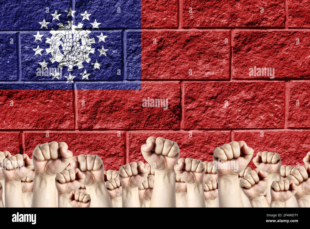 Raised fists against the background of the depicted flag of Myanmar ...