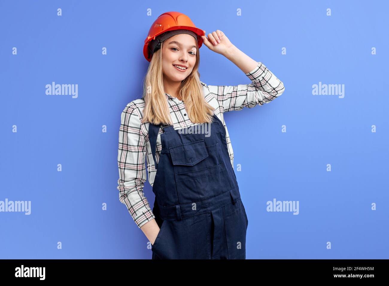 Female engineer with orange helmet standing with positive expression ...