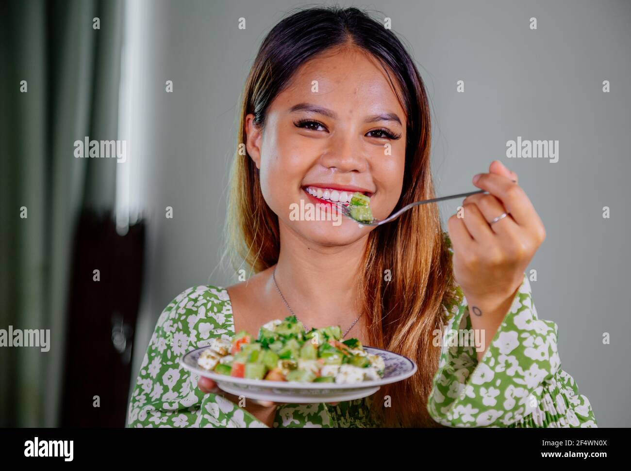 beautiful young asian woman eating healthy mediterranean food. smiling ...