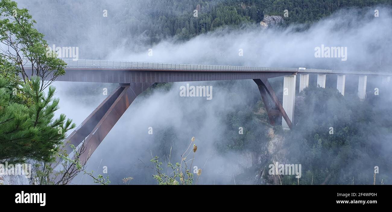 the Cadore bridge located in the Dolomites with the fog that clears as ...