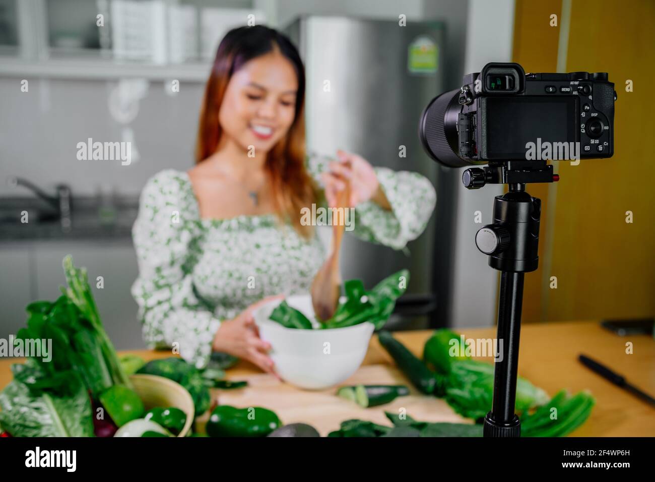 Asian woman blogger or content creator cooking and recording video ...