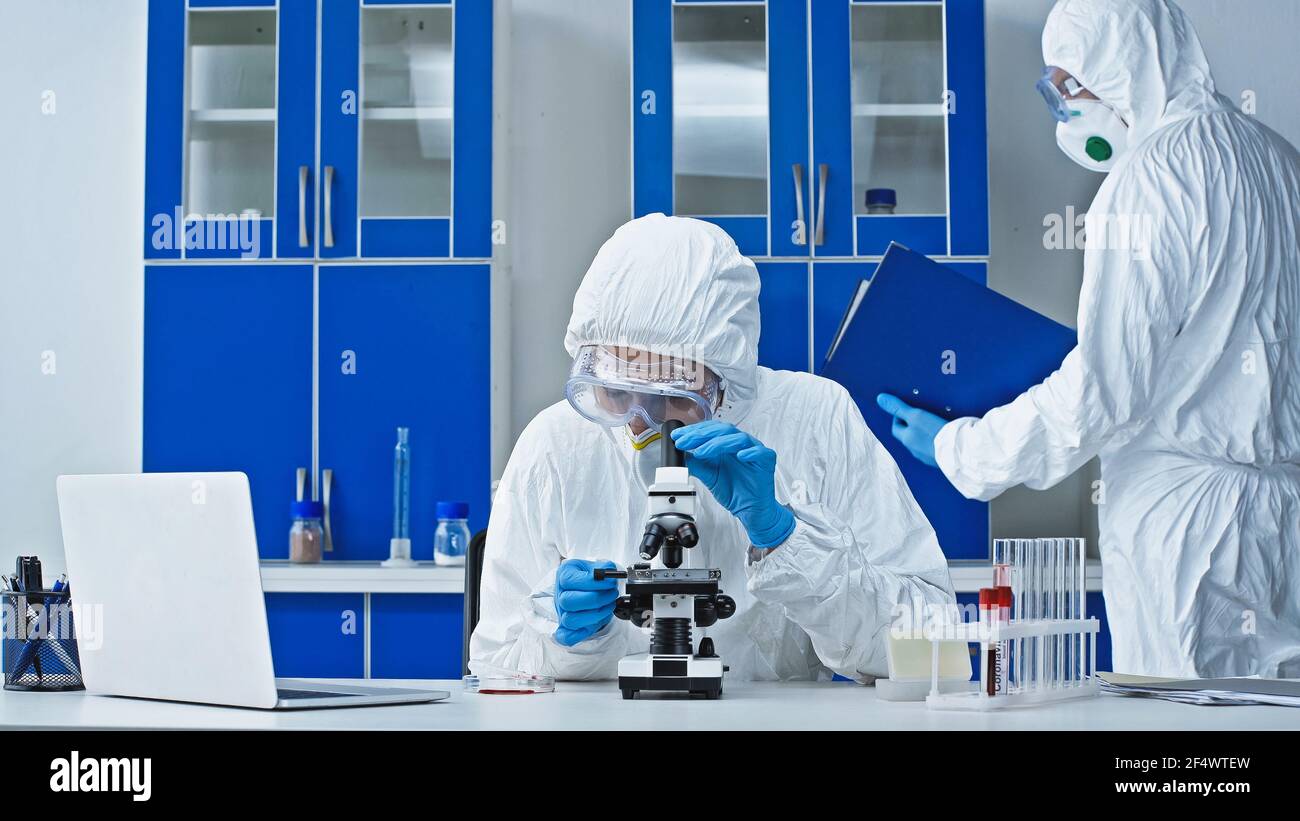 Virologist working microscope colleague hi-res stock photography and ...