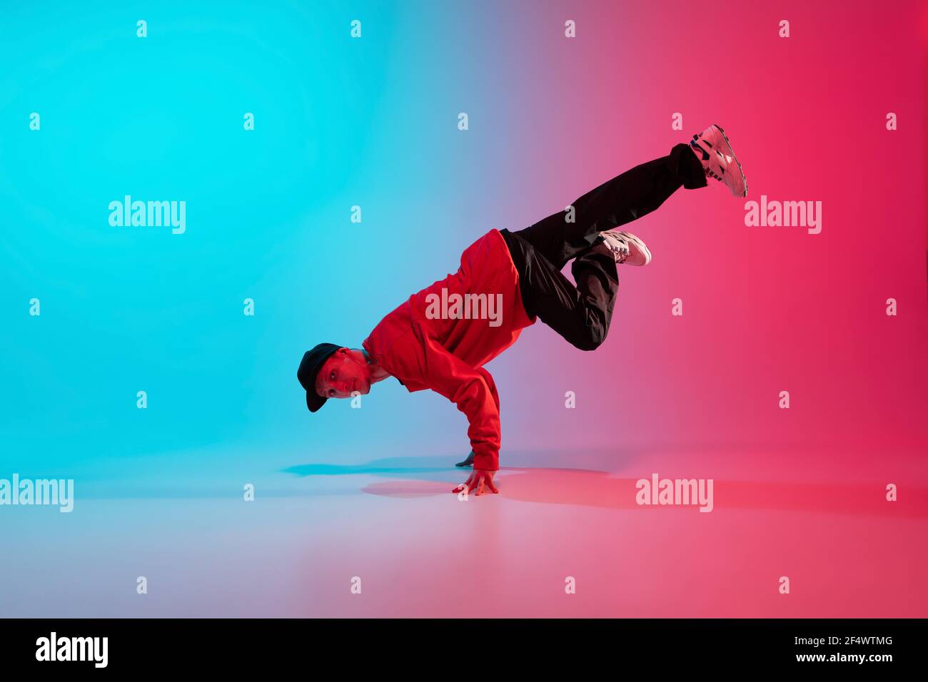 Beautiful sportive boy dancing hip-hop in stylish clothes on colorful ...