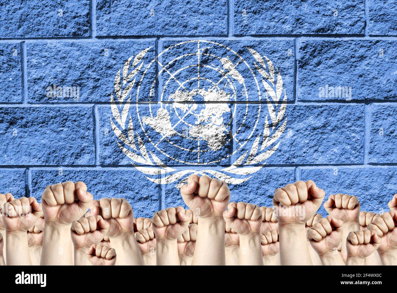 Raised fists against the background of the depicted flag of UN on a ...