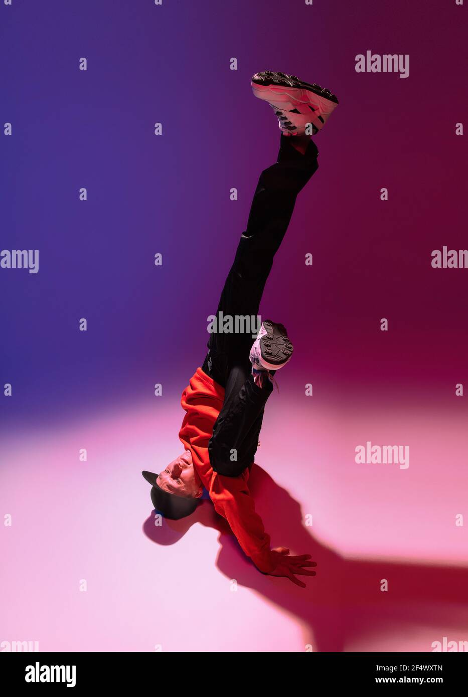 Beautiful sportive boy dancing hip-hop in stylish clothes on colorful ...