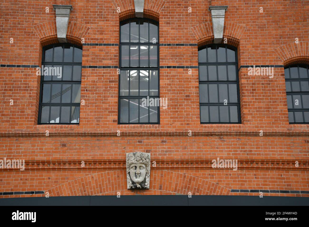 Old Victorian building brick facade with symmetrical arched windows in ...