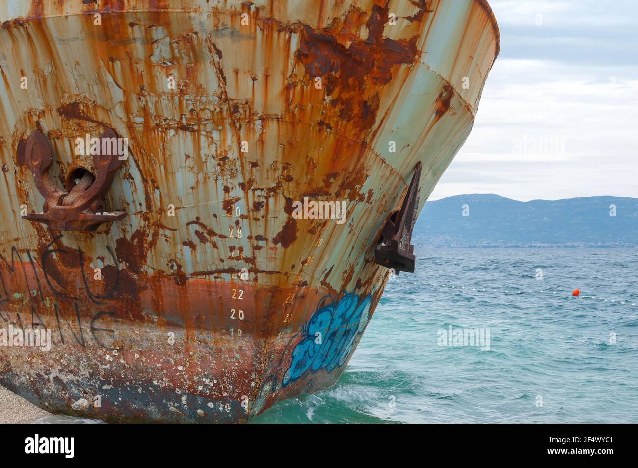 Close-up at the bow of corroded and abandoned shipwreck washed ashore ...