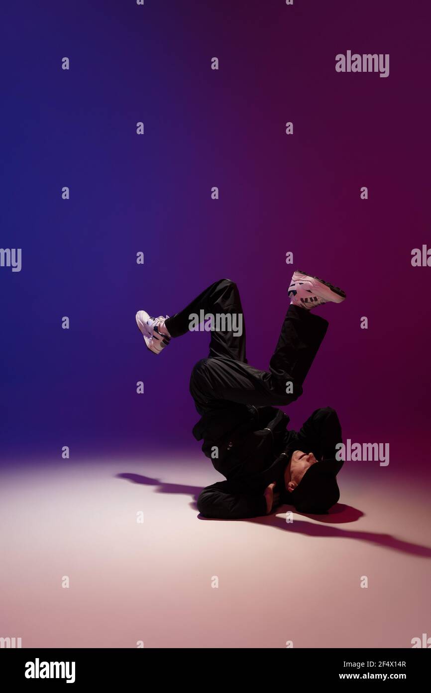 Beautiful sportive boy dancing hip-hop in stylish clothes on colorful ...