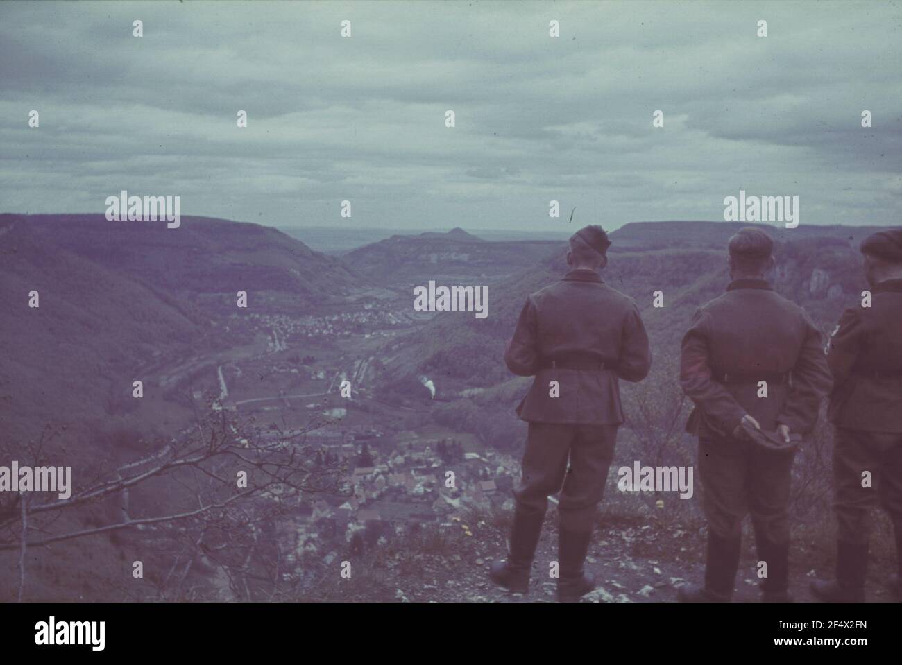 Second World War. Three Wehrmachlichige, looking into a mountain valley ...