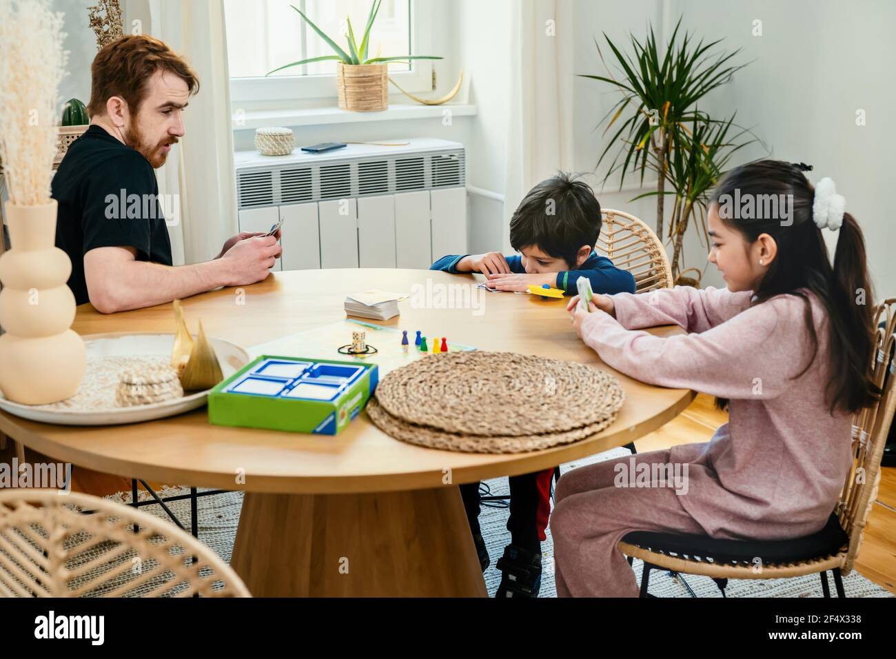 Father and kids playing with board game together at the table Stock ...