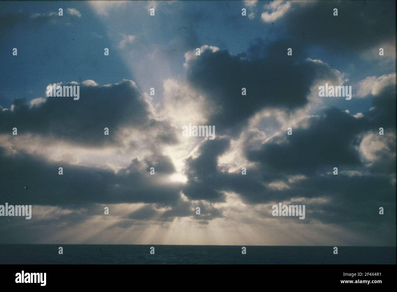 Travel photos. Sunset behind cumulus clouds and with cloud beams Stock Photo - Alamy