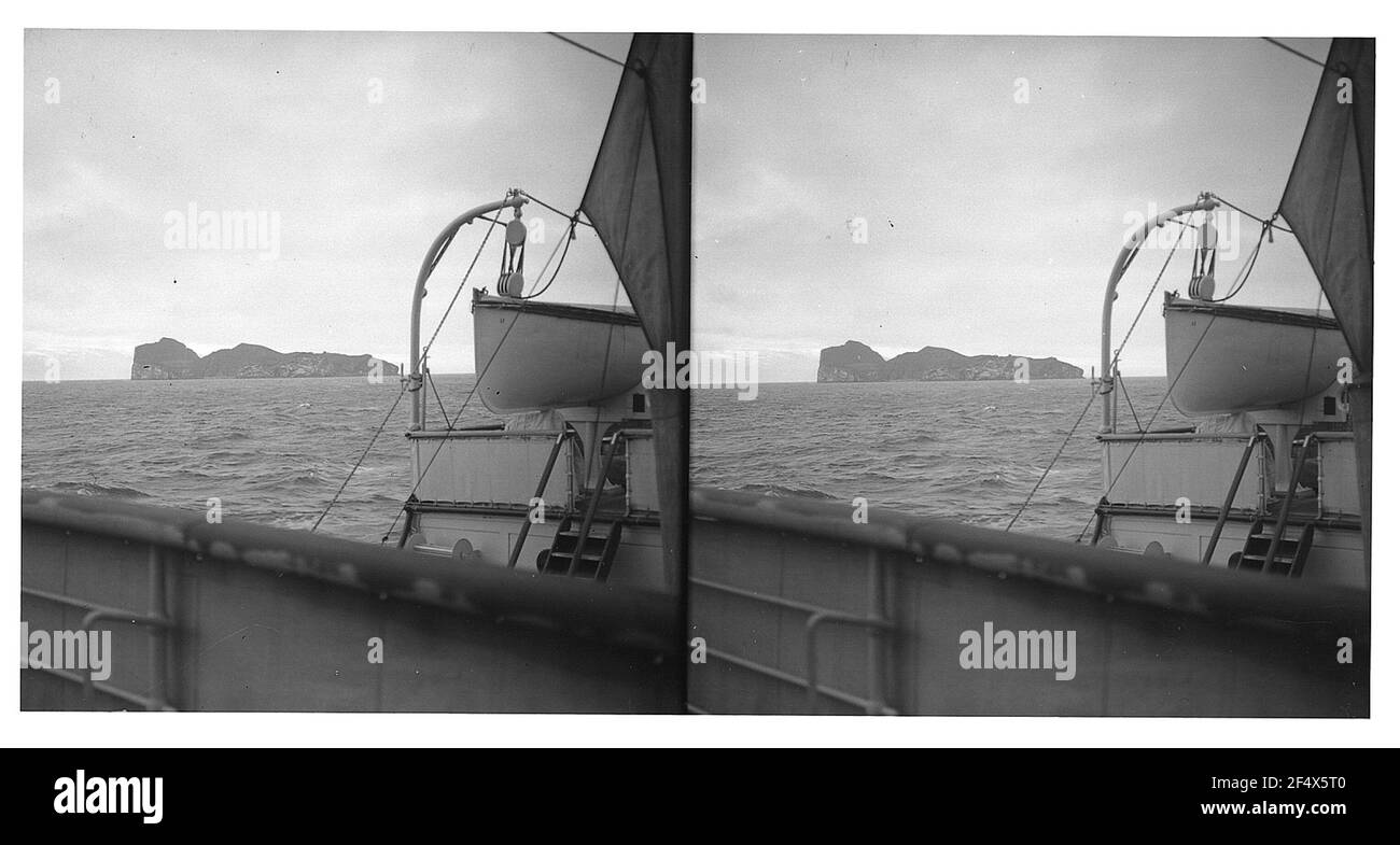 View from the ship with reeling and lifeboat on rock or island in the ...