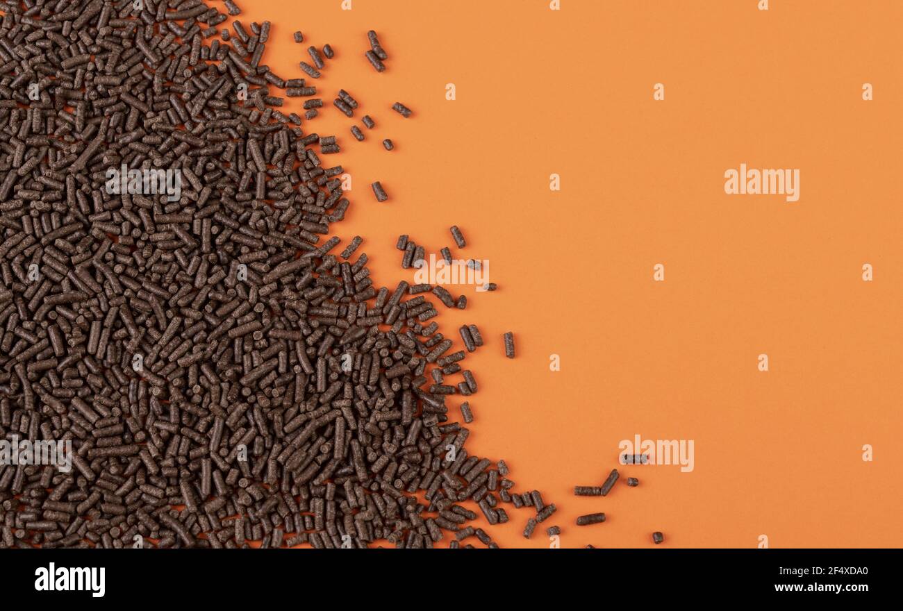 Dark chocolate sprinkles over orange background with copy space ...