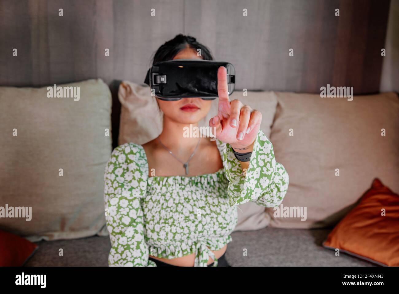 Asian Woman looking through virtual reality device at home. Augmented ...