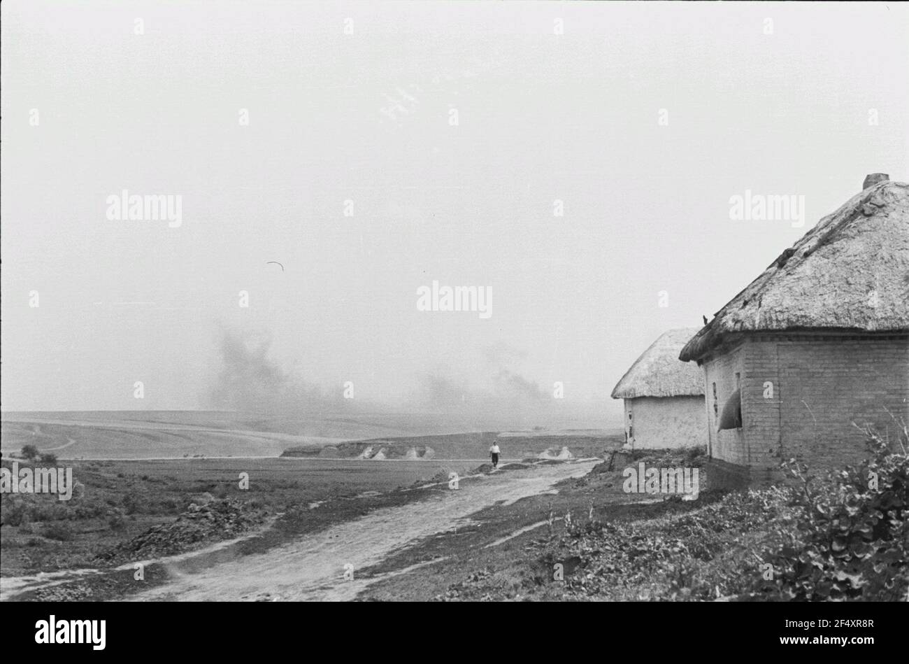 Second World War. After the fighting. Woman before abandoned houses ...