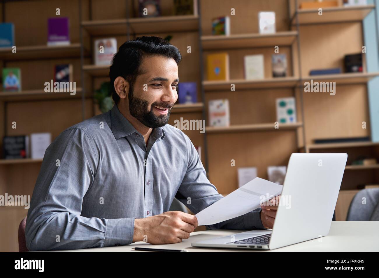 Smiling indian business man holding cv document having virtual job ...