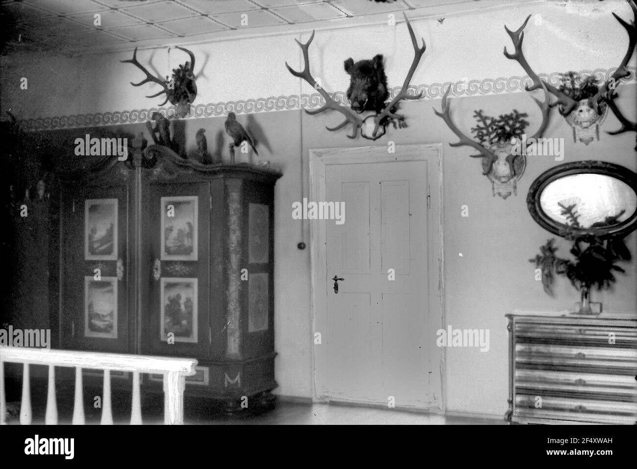 Cabinet with artistic painting and hunting trophies Stock Photo - Alamy