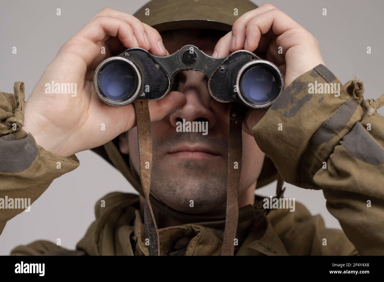 Adult man with binoculars in hand in an old military uniform and ...