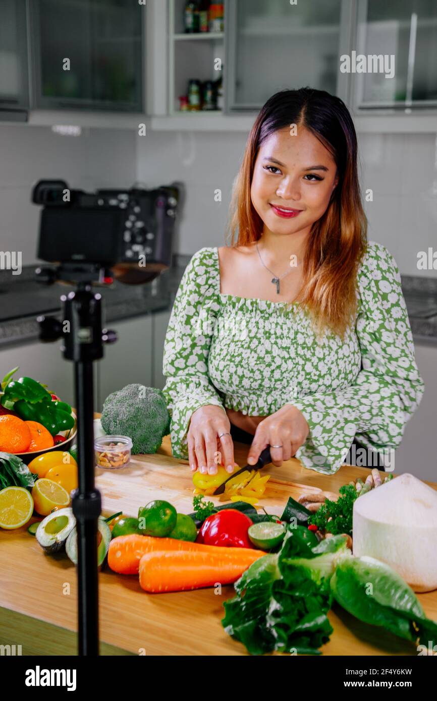 Asian woman blogger or content creator cooking and recording video ...