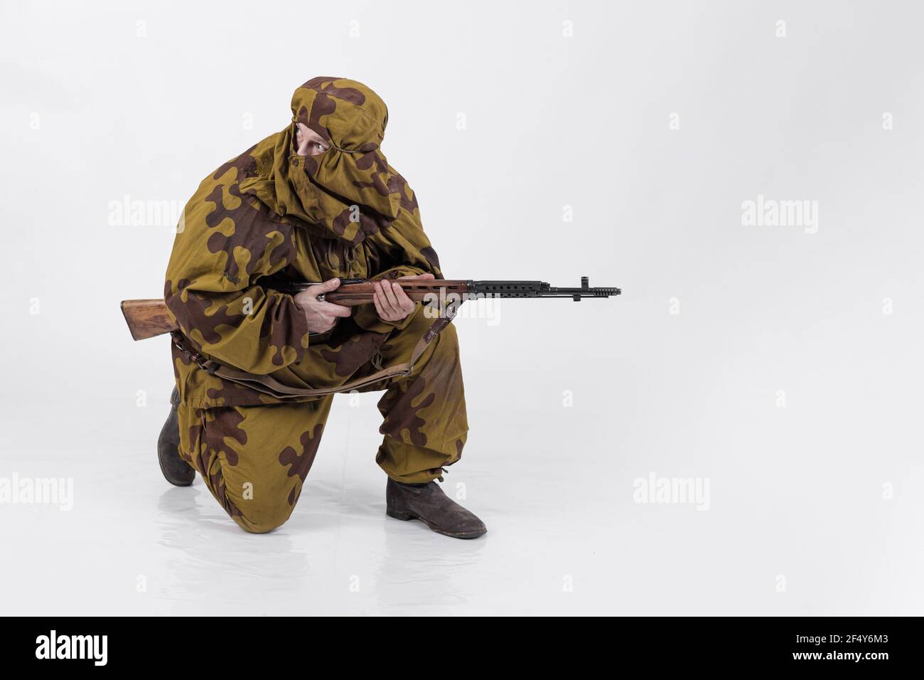 Actor man in an old military uniform and camouflage sniper marksman ...