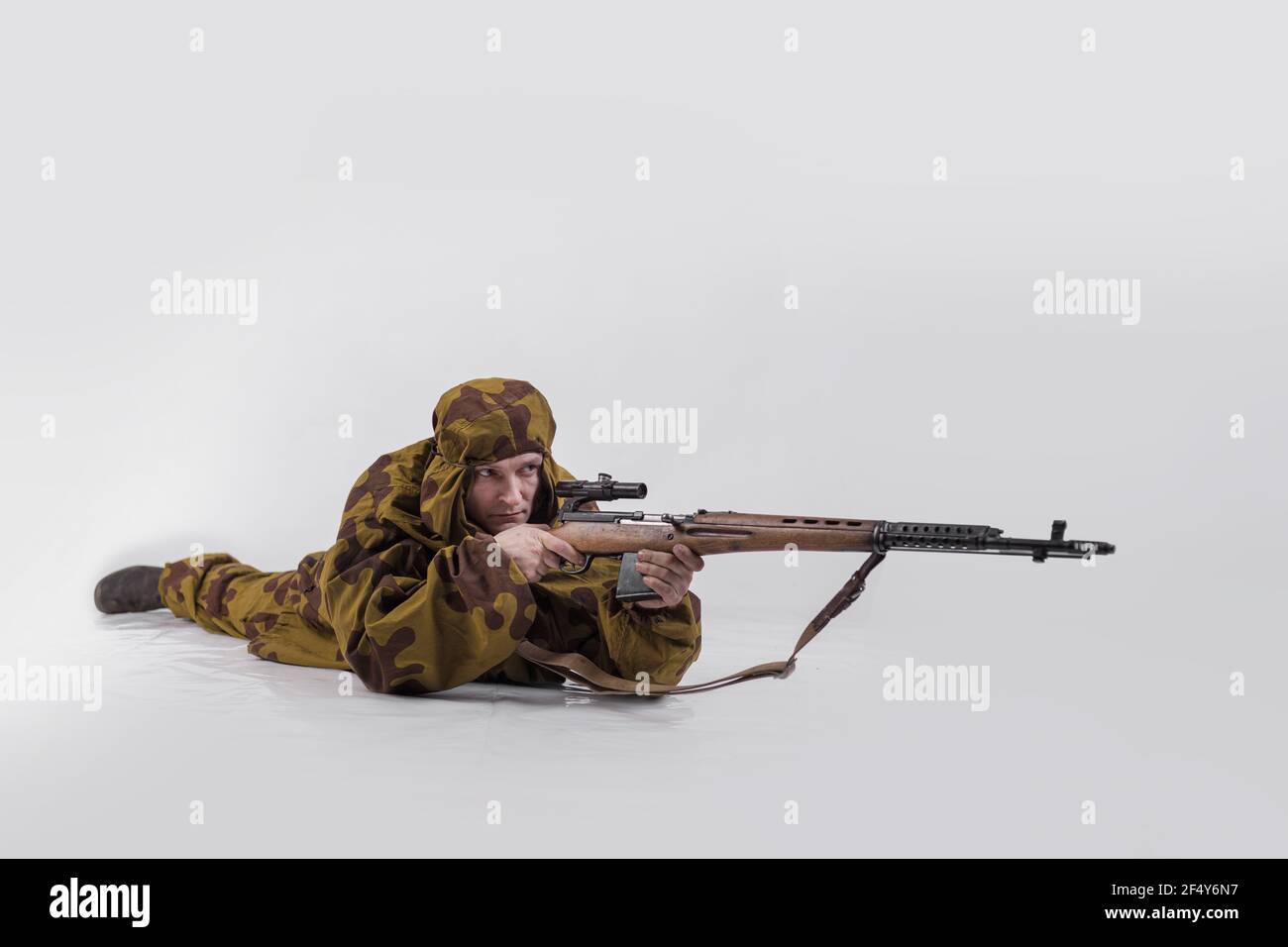 Actor man in an old military uniform and camouflage sniper marksman ...