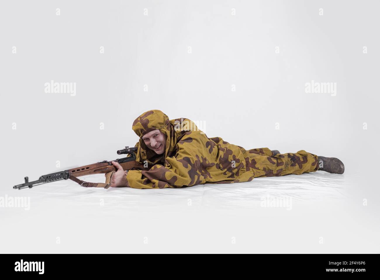 Actor man in an old military uniform and camouflage sniper marksman ...