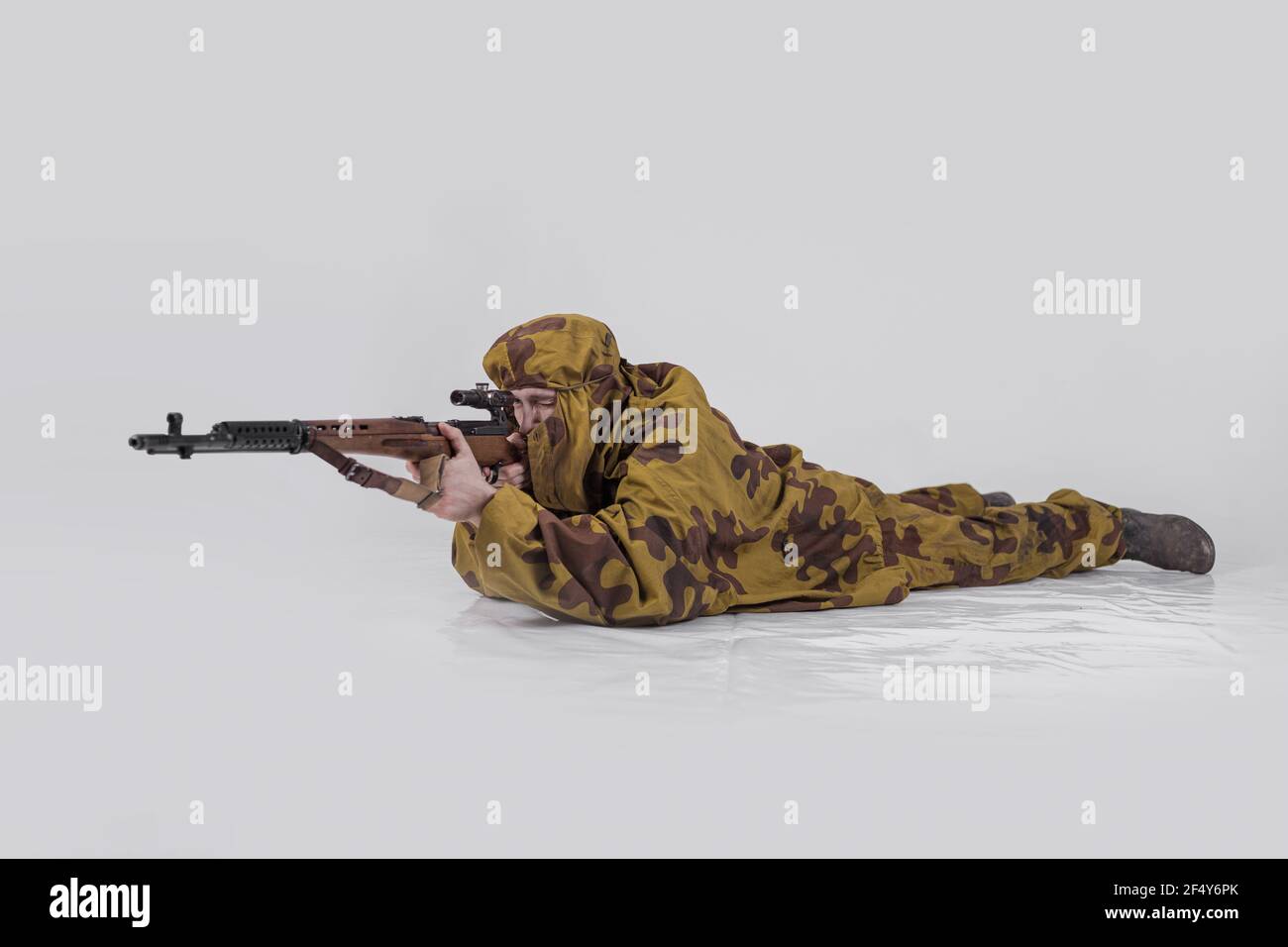 Actor man in an old military uniform and camouflage sniper marksman ...