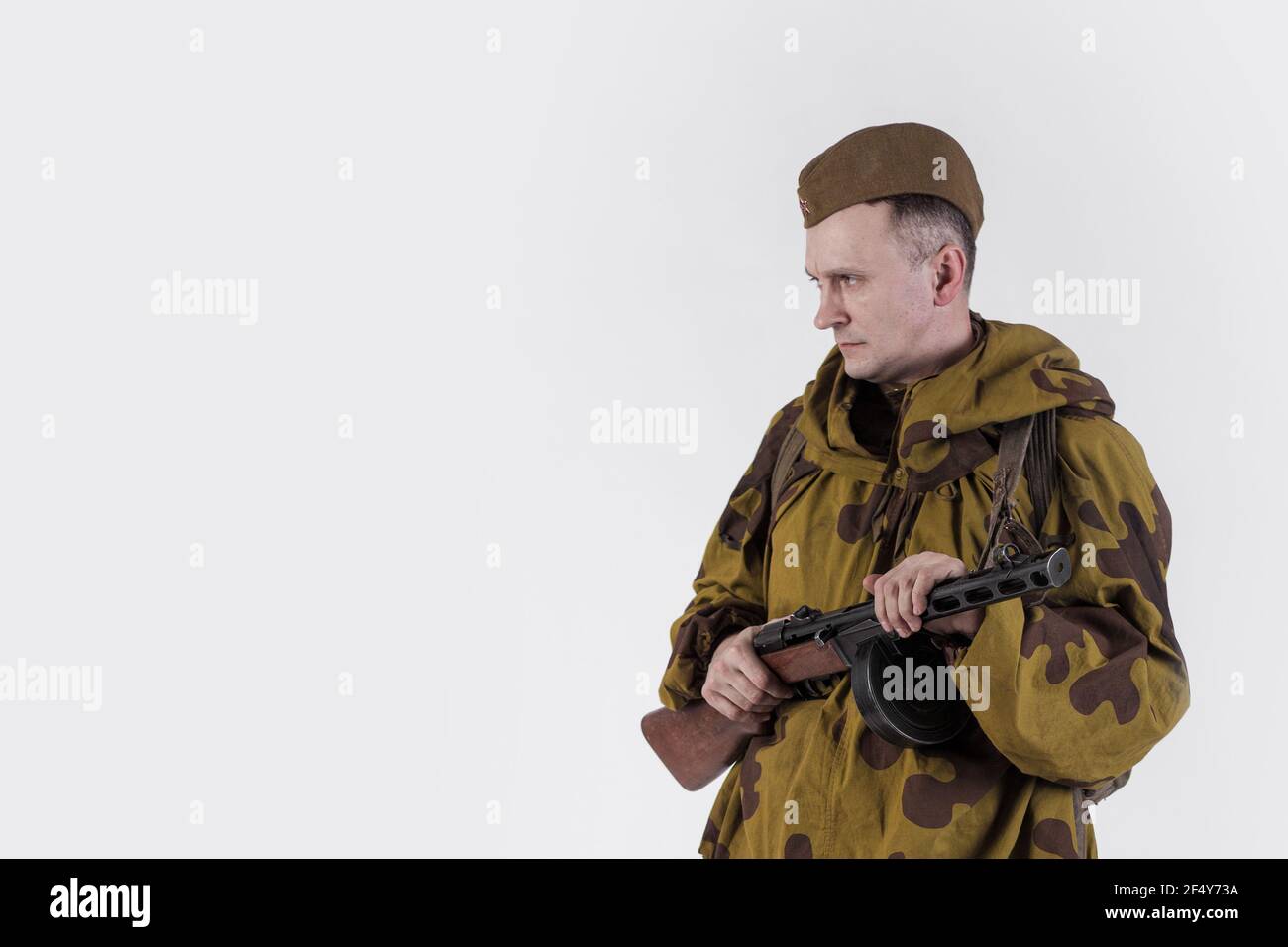 Actor man in an old military uniform and camouflage sniper marksman ...