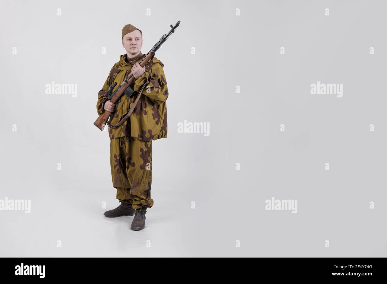 Actor man in an old military uniform and camouflage sniper marksman ...