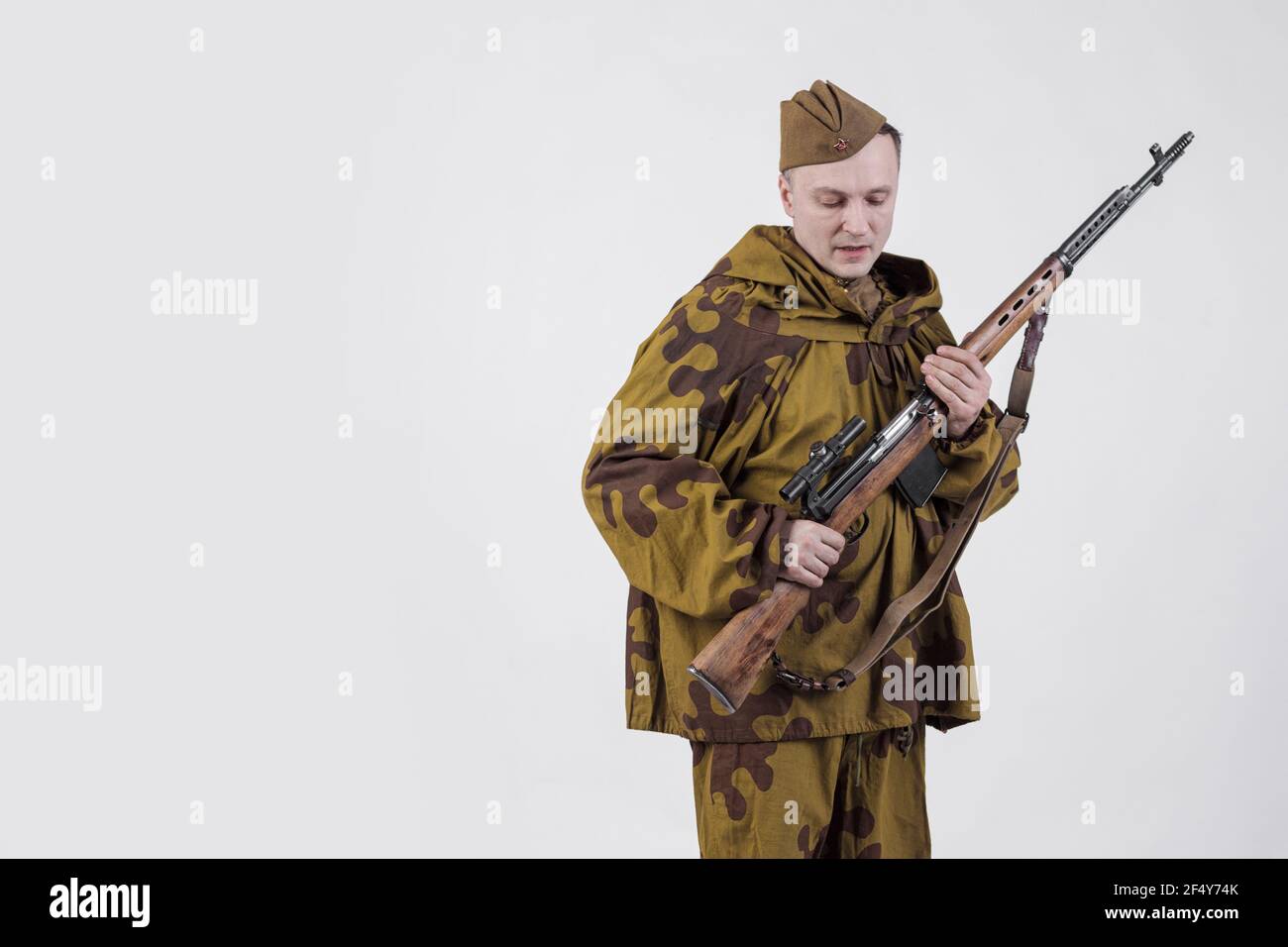Actor man in an old military uniform and camouflage sniper marksman ...