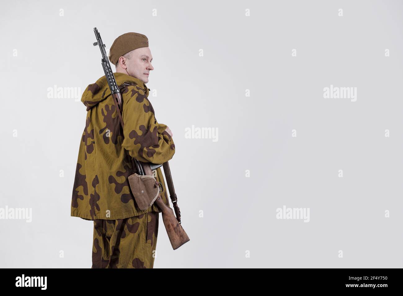 Actor man in an old military uniform and camouflage sniper marksman ...