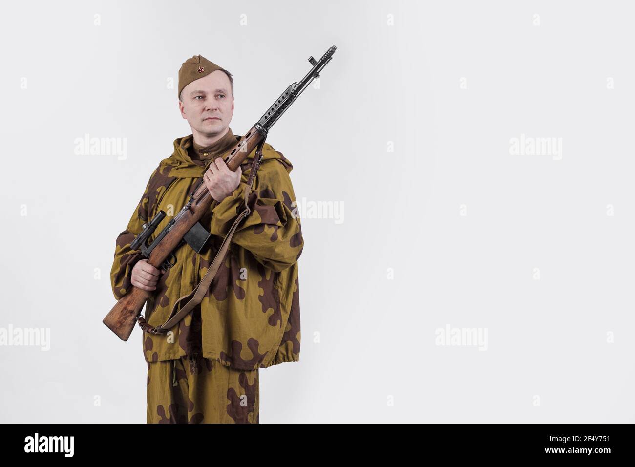 Actor man in an old military uniform and camouflage sniper marksman ...