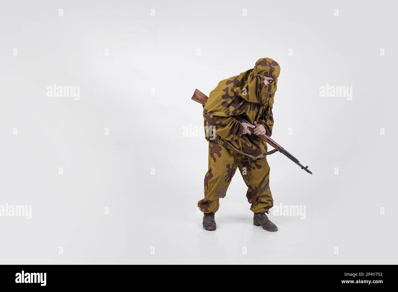 Actor man in an old military uniform and camouflage sniper marksman ...