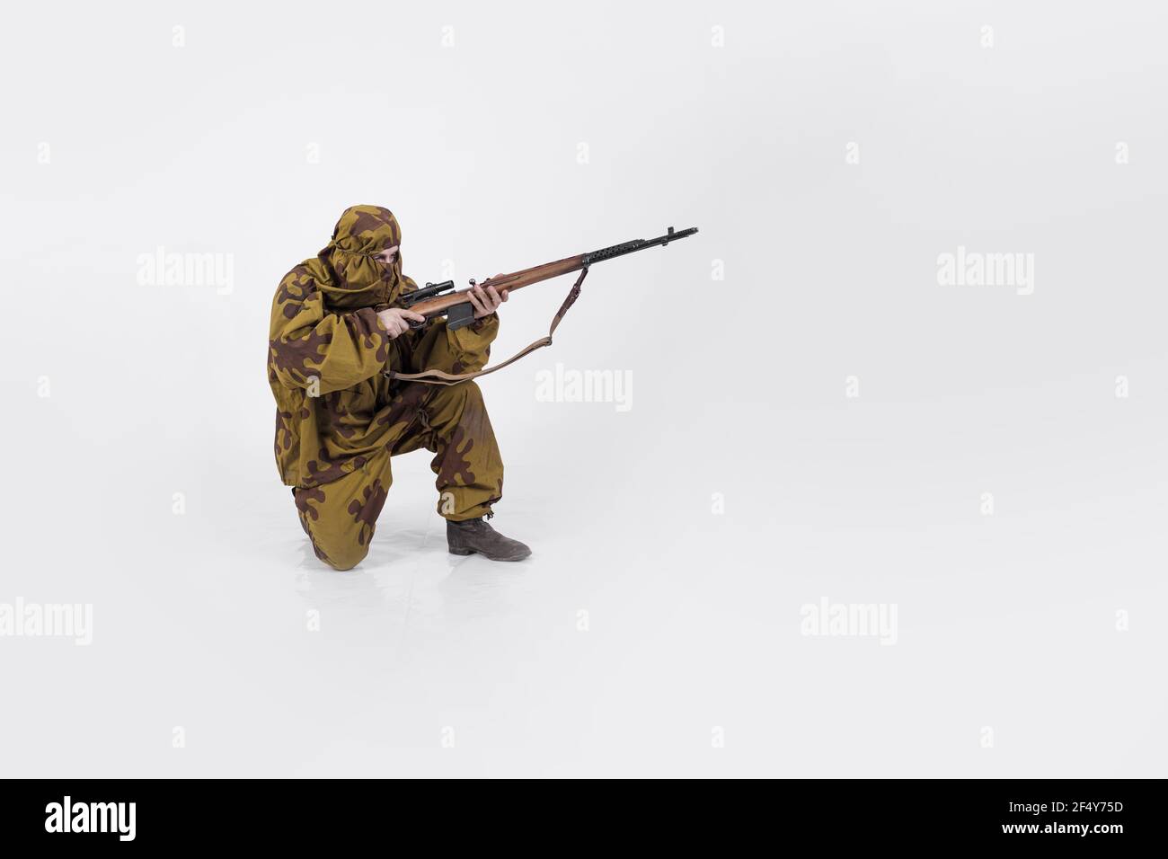 Actor man in an old military uniform and camouflage sniper marksman ...
