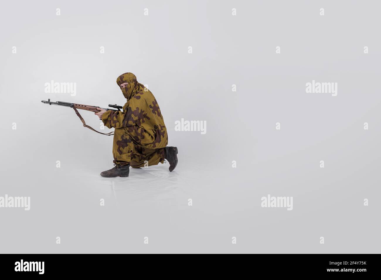 Actor man in an old military uniform and camouflage sniper marksman ...