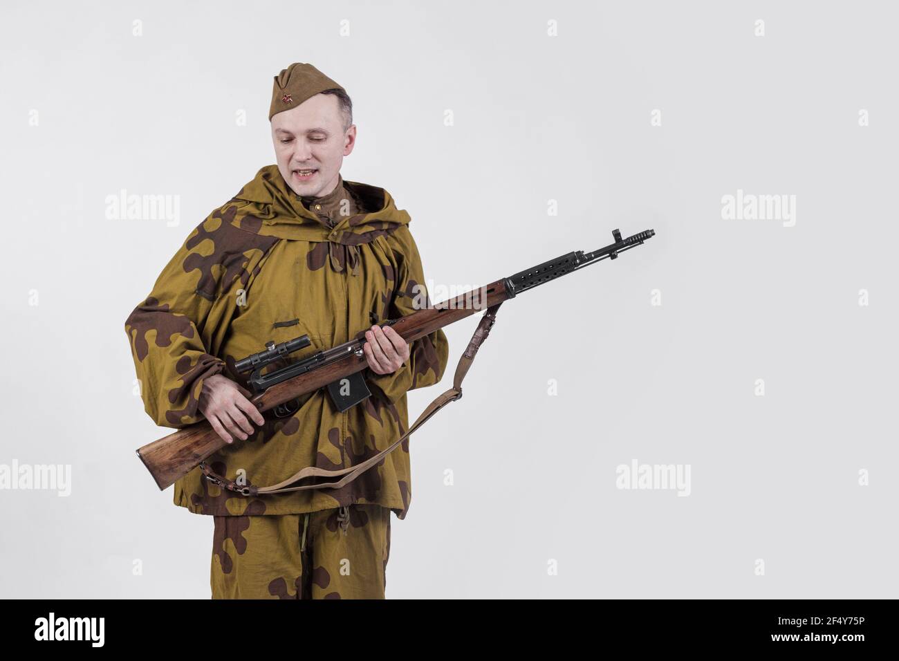 Actor man in an old military uniform and camouflage sniper marksman ...