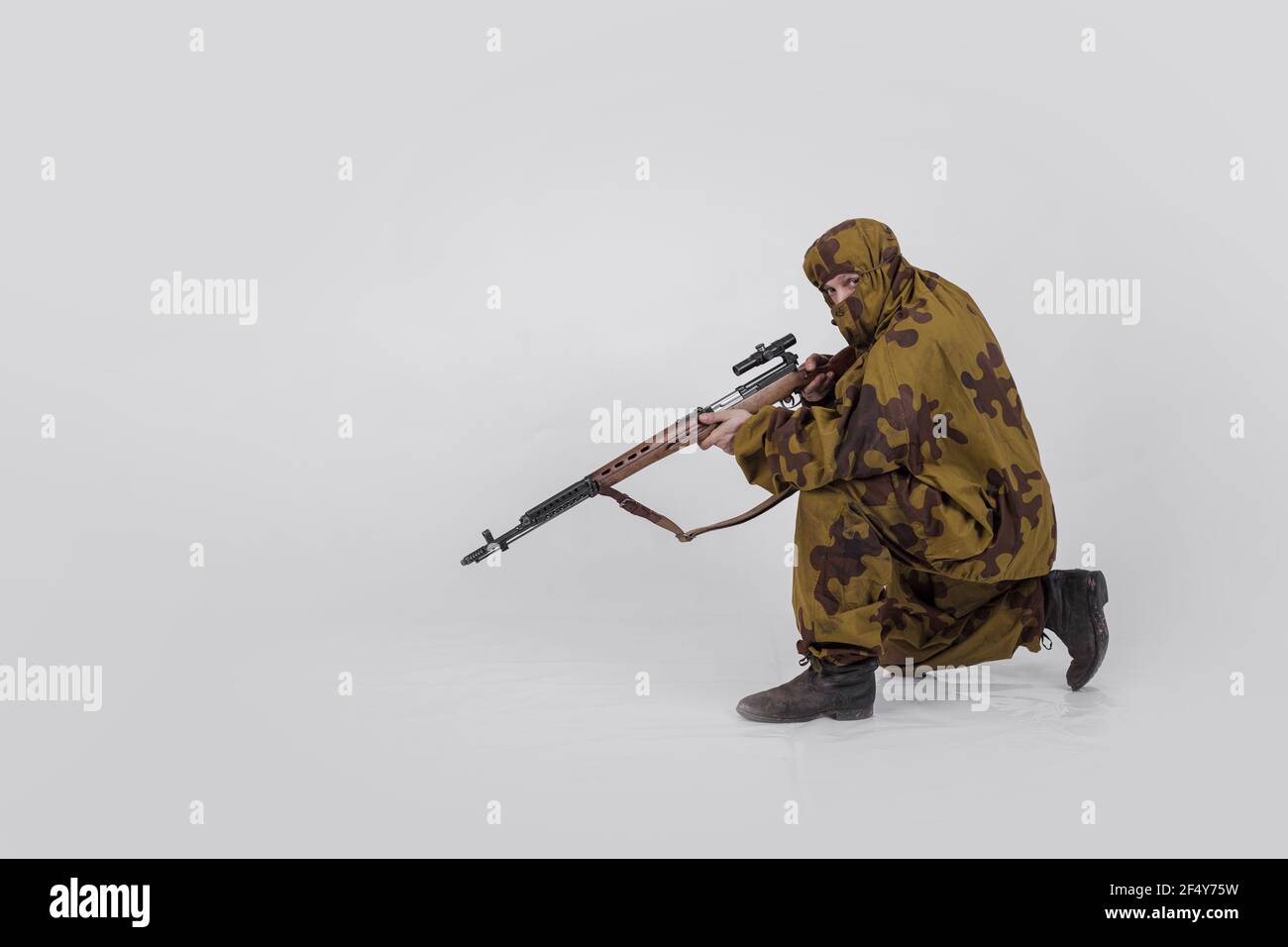 Actor man in an old military uniform and camouflage sniper marksman ...