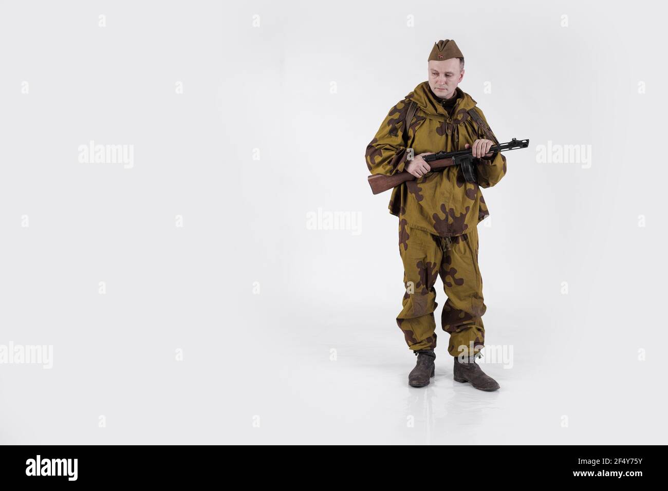 Actor man in an old military uniform and camouflage sniper marksman ...