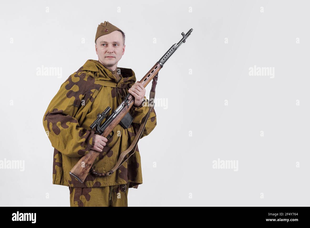 Actor man in an old military uniform and camouflage sniper marksman ...