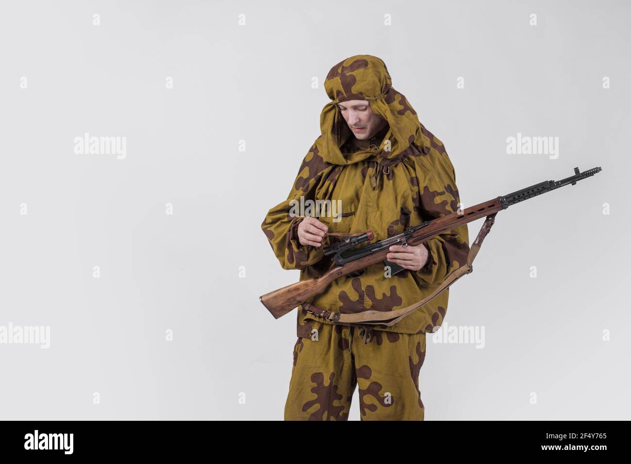 Actor man in an old military uniform and camouflage sniper marksman ...