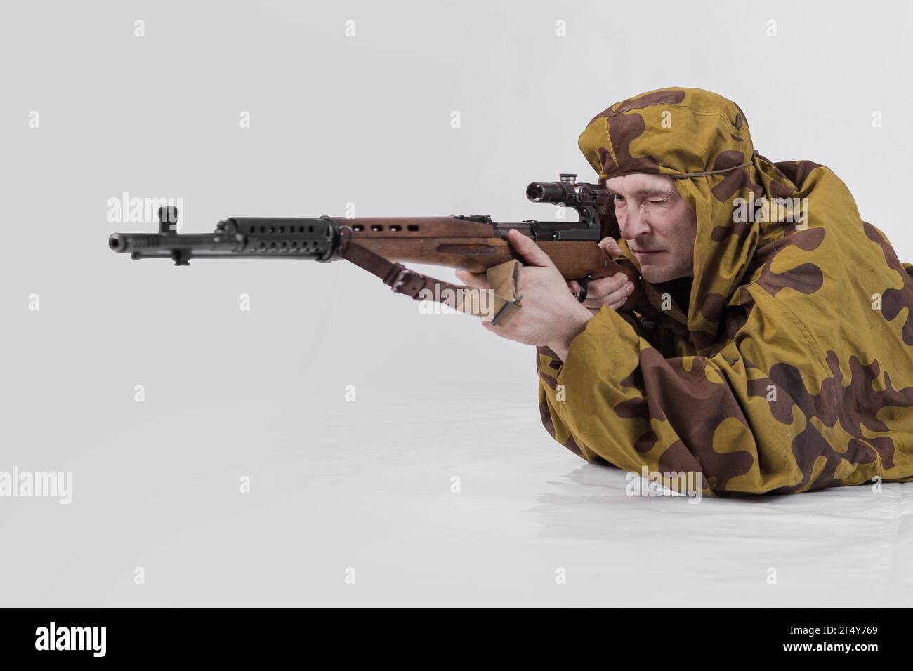 Actor man in an old military uniform and camouflage sniper marksman ...