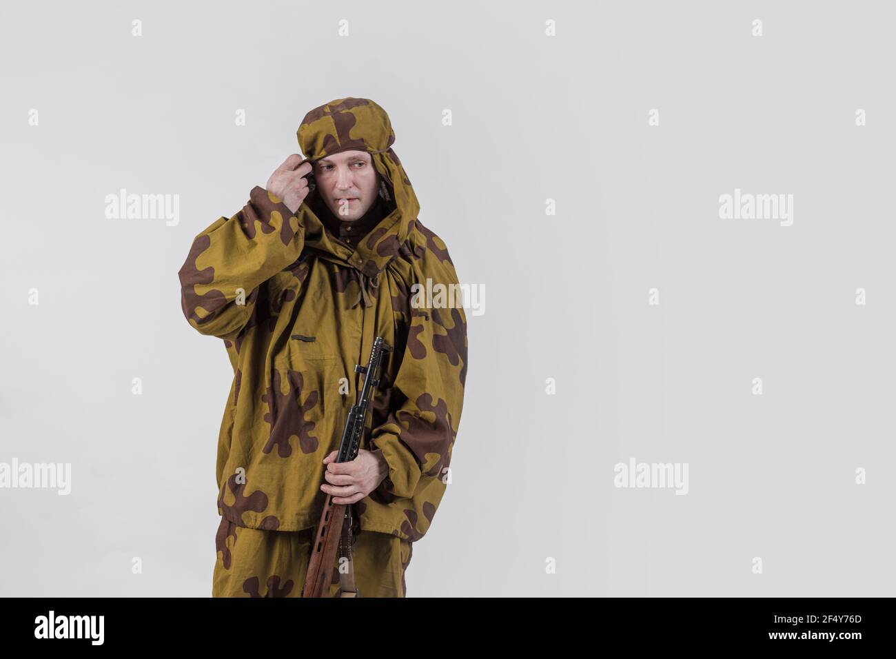 Actor man in an old military uniform and camouflage sniper marksman ...