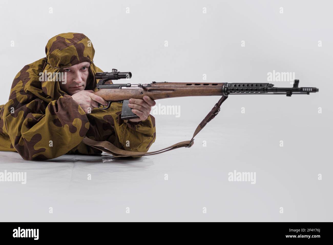 Actor man in an old military uniform and camouflage sniper marksman ...