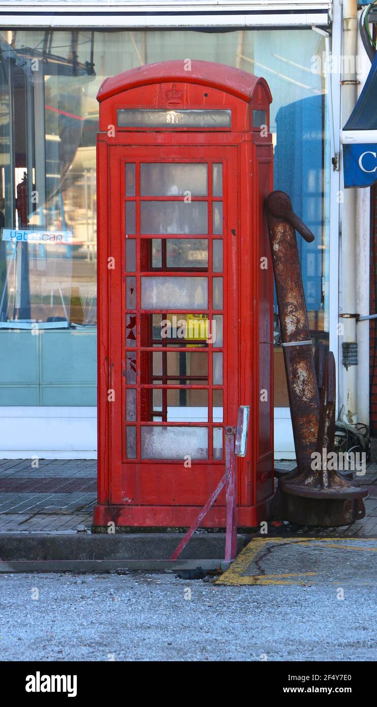 Classic British old red painted telephone box with broken glass ...