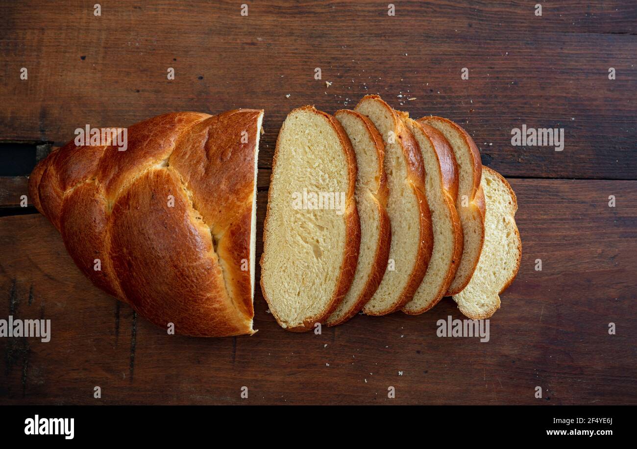 Easter sweet bread, tsoureki cozonac loaf slices on wooden table ...