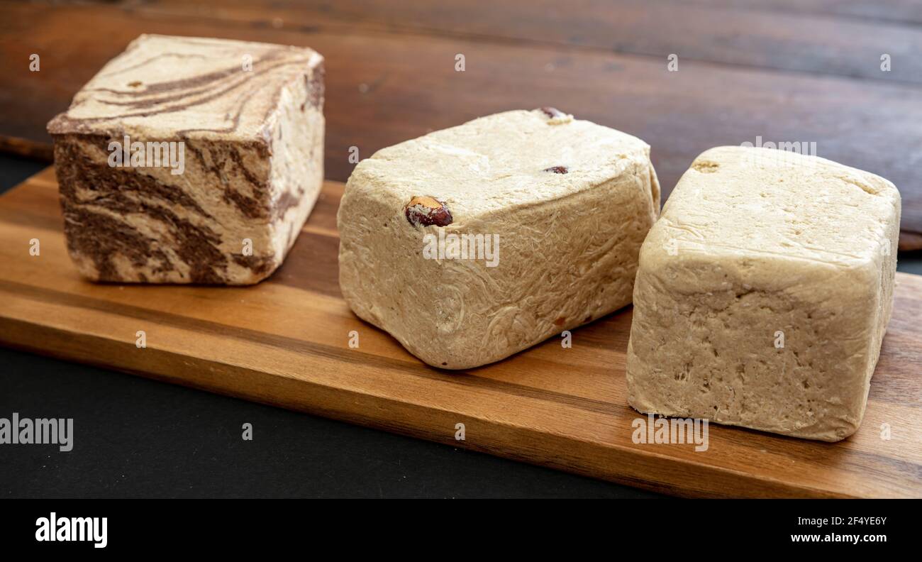 Halva variety vanilla cocoa and almonds on wooden table background ...