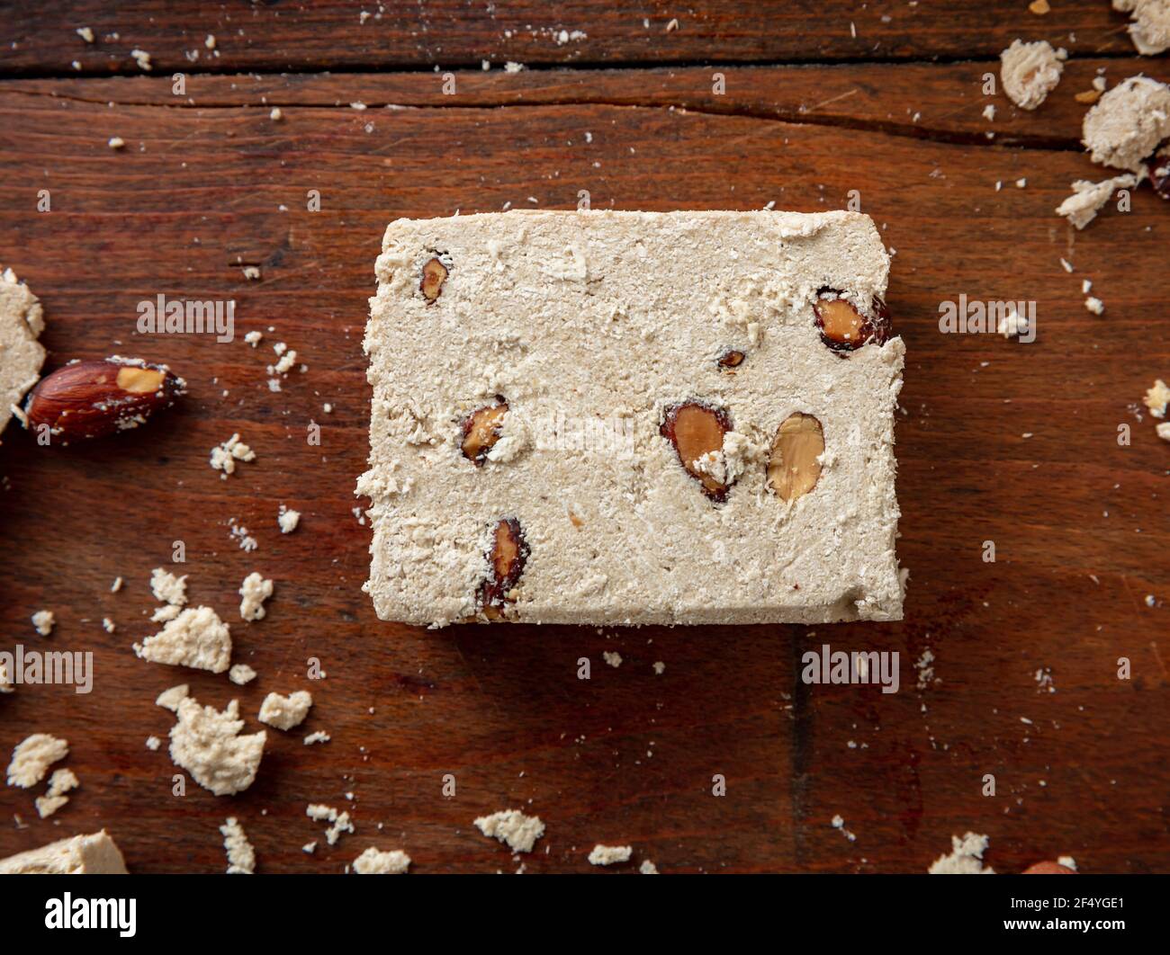 Halva piece with almond nuts on wooden table background, top view ...