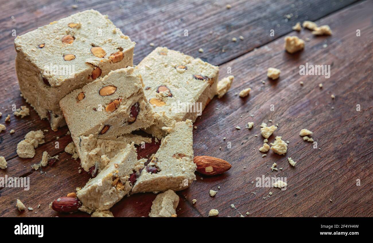 Halva sesame tahini and almonds on wooden table background. Vanilla ...