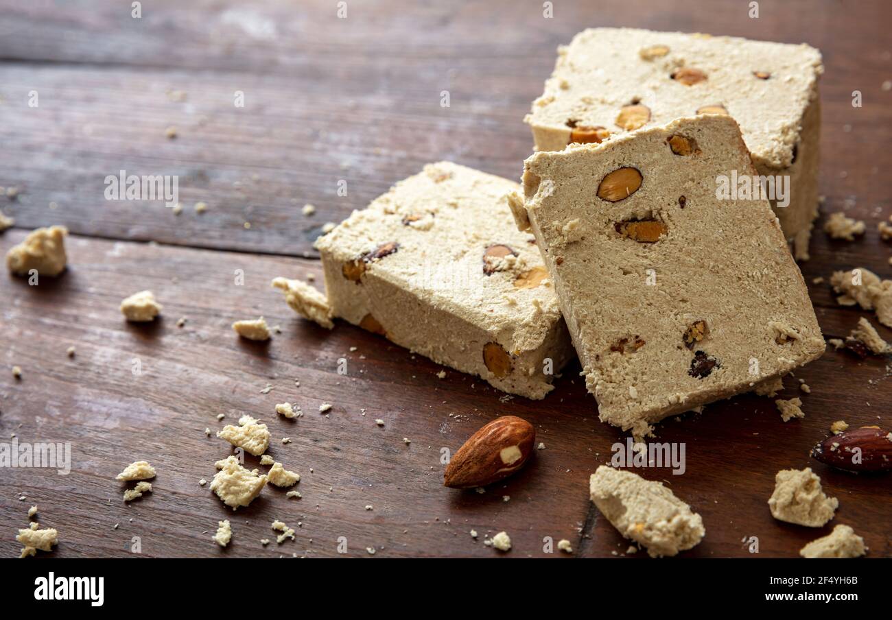Halva sunflower and almonds on wooden table background. Vanilla halvah ...